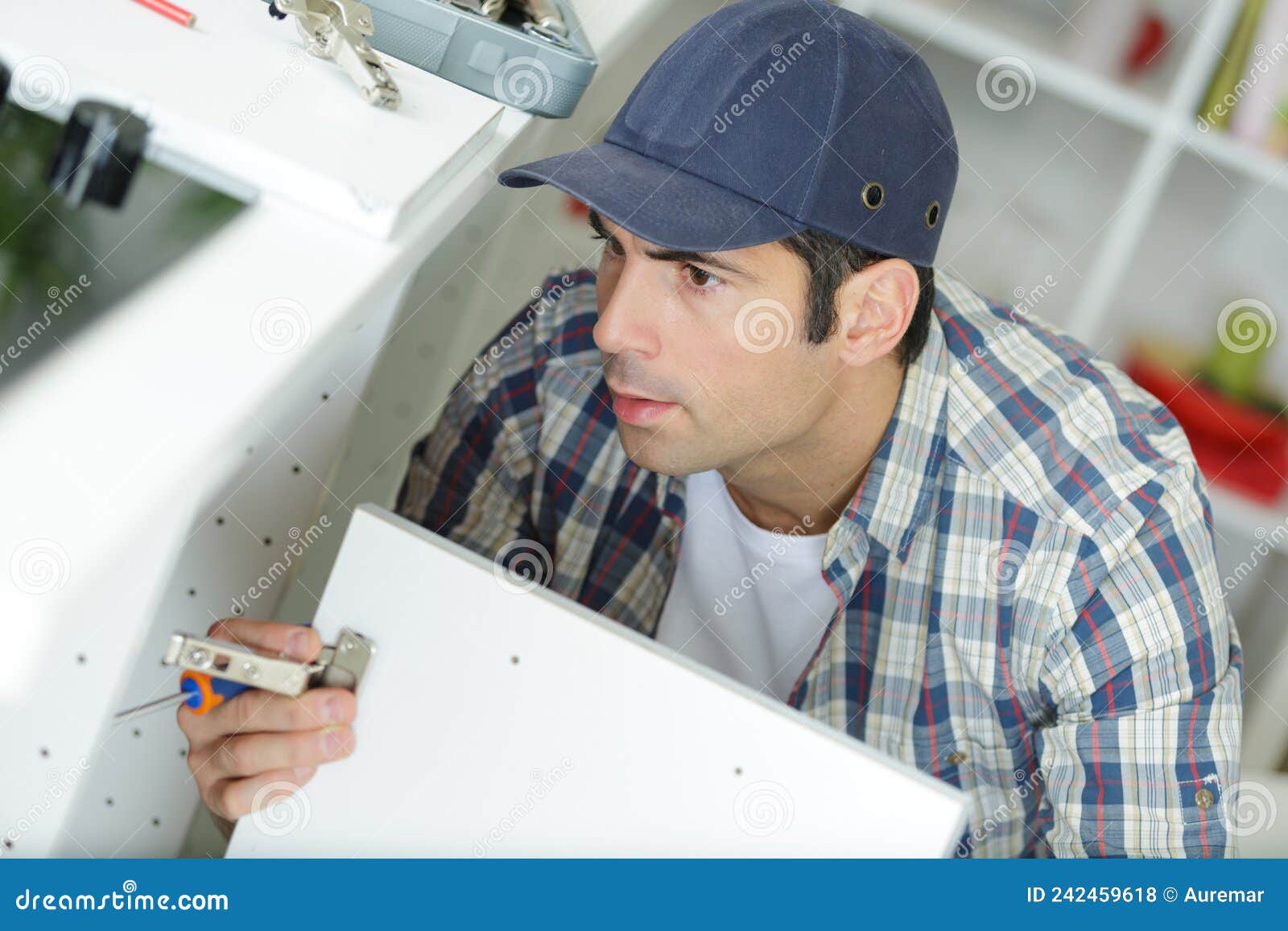 Man fixing cabinet door stock photo. Image of hanging - 242459618