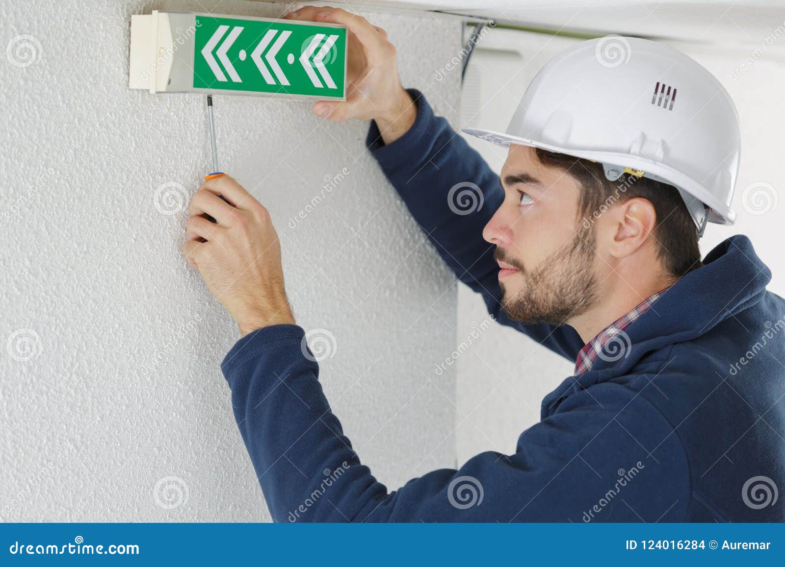 Man Fixing Illuminated Exit Sign To Wall Stock Photo - Image of ...