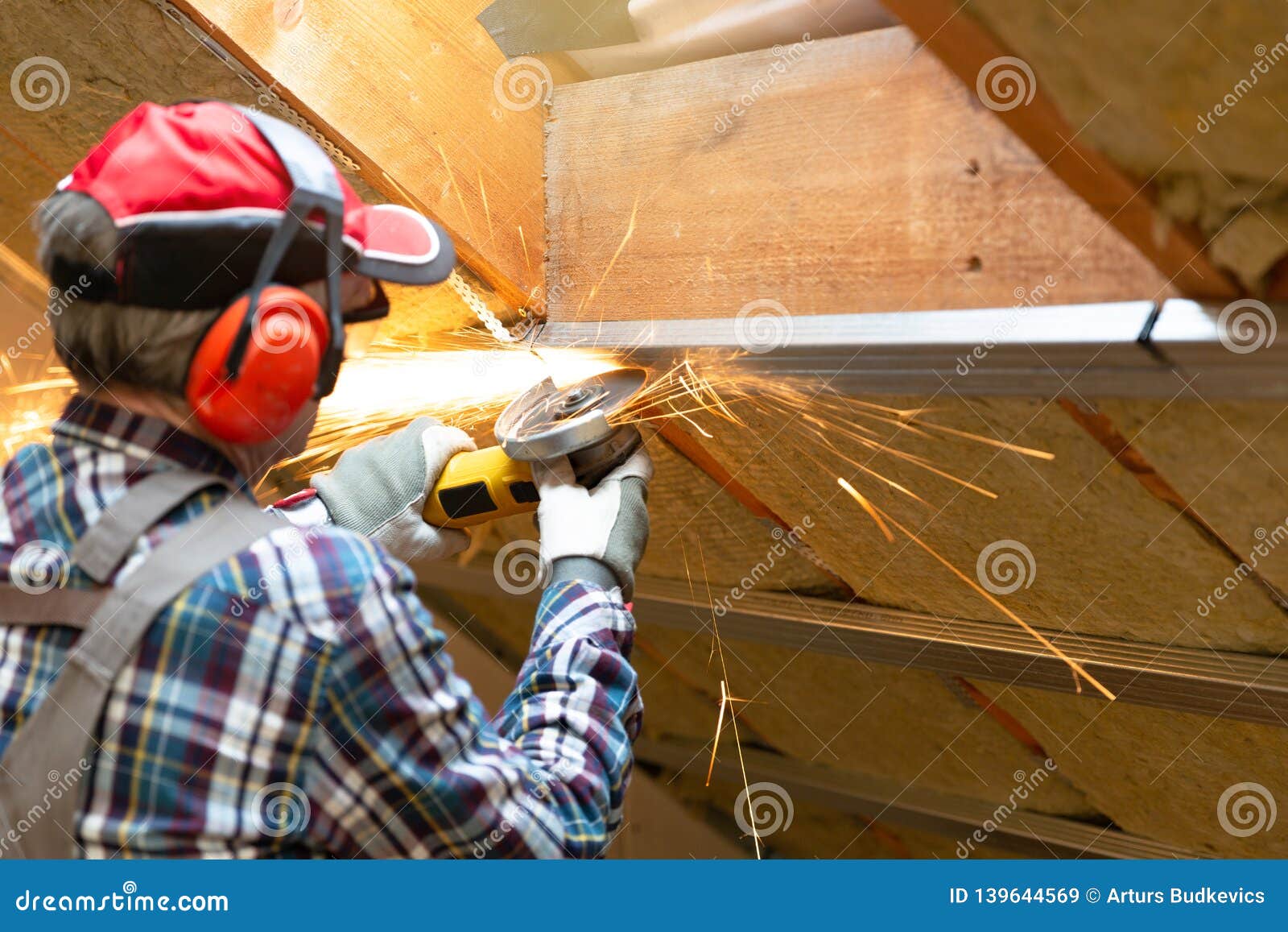Man Fixing Metal Frame Using Angle Grinder on Attic Ceiling Covered ...