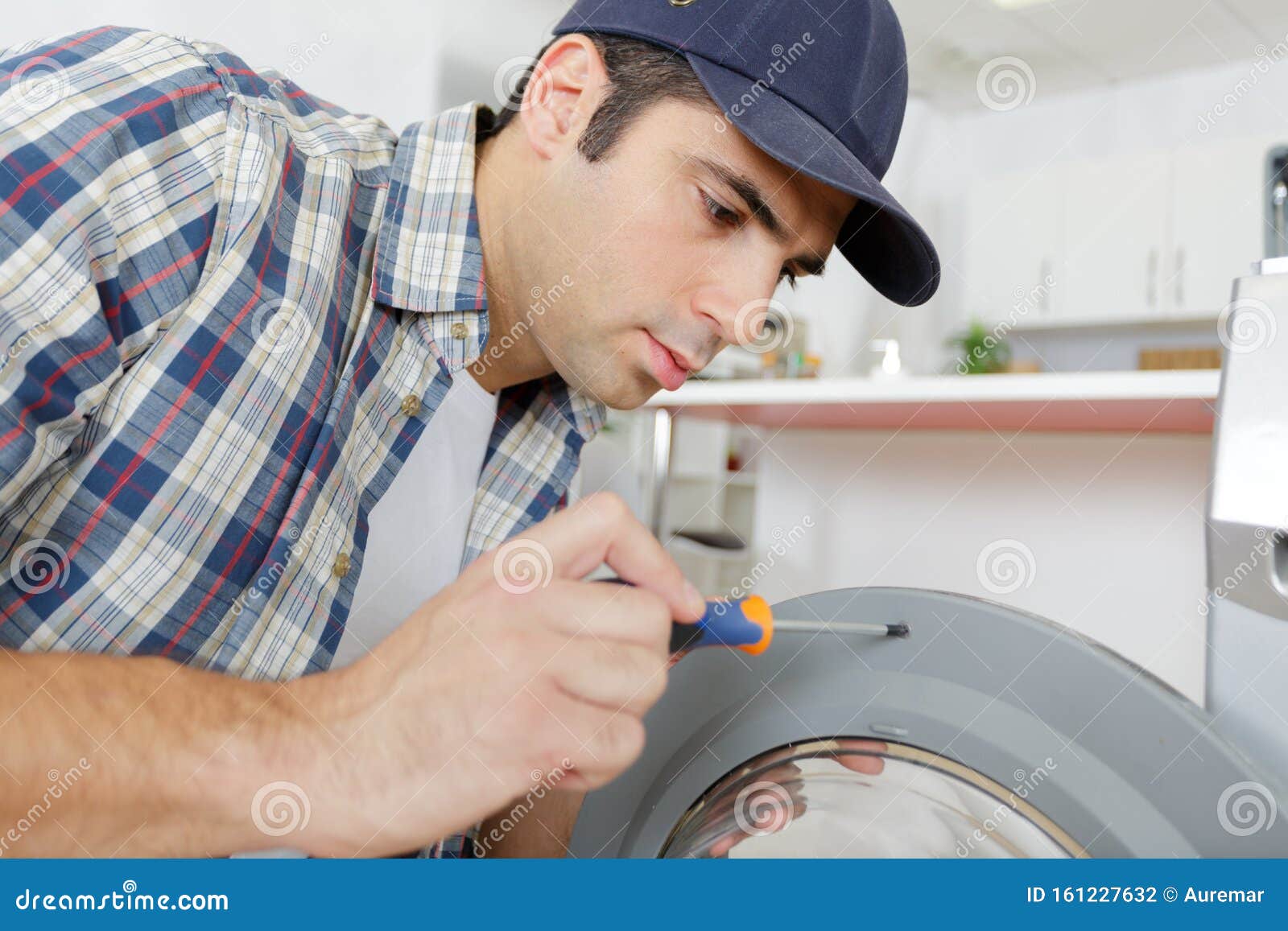 Man fixing washing machine stock photo. Image of tool - 161227632