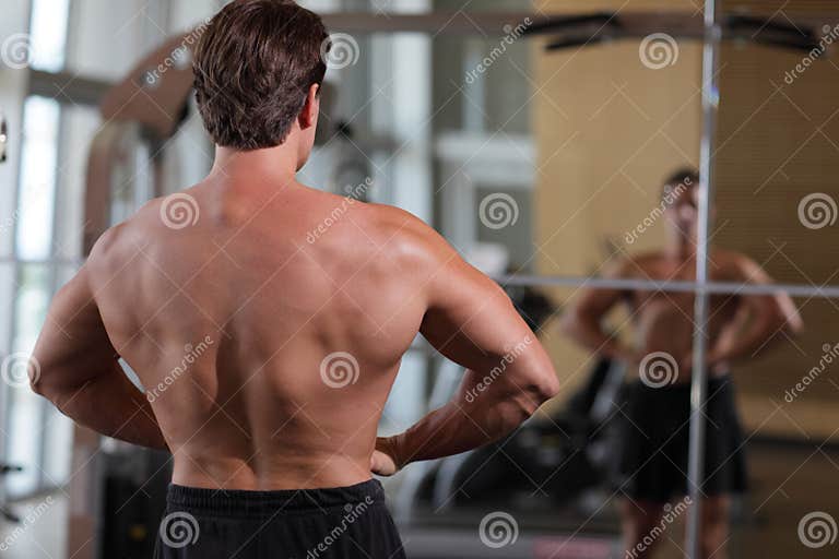 Man flexing by the mirror stock photo. Image of strength - 26263098