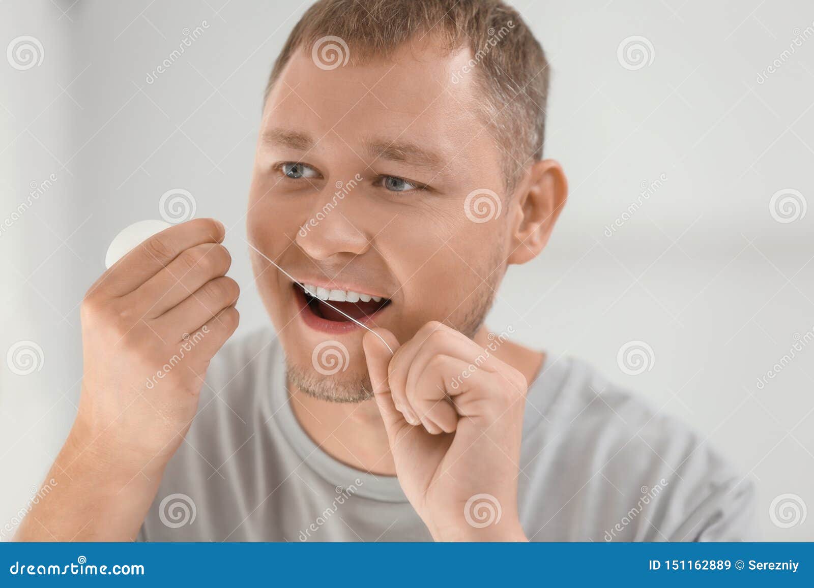 Man Flossing His Teeth on Light Background Stock Image - Image of ...