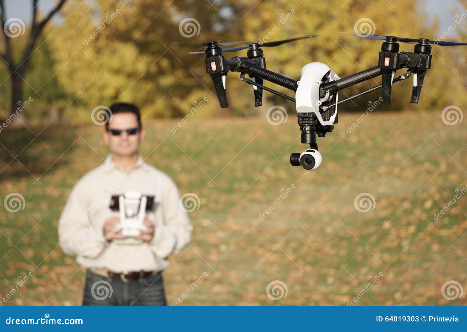Man Flying a High-Tech Camera Drone (Fall Trees & Leaves in Background ...