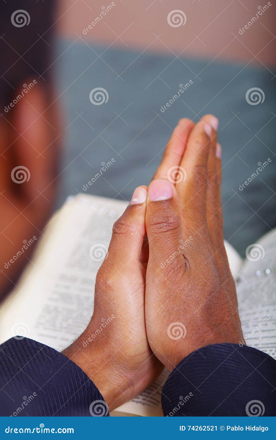 Man Folding Hands Praying with Open Bible Lying in Front, Seen from ...