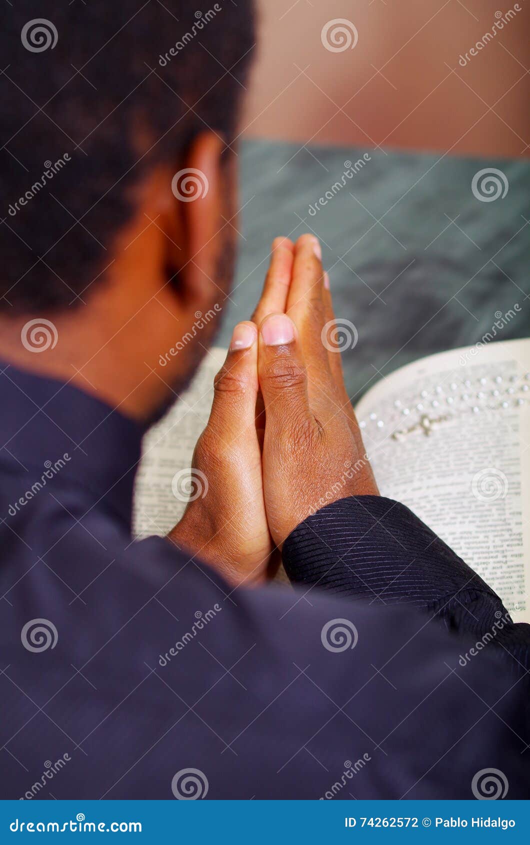 Man Folding Hands Praying With Open Bible Lying In Front, Seen From ...