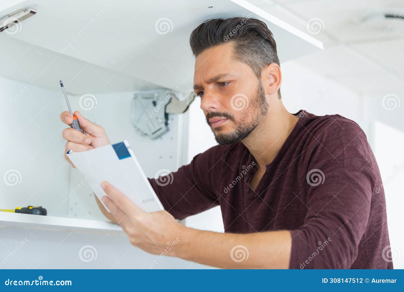 Man Following Instructions To Install Cupboard Stock Photo - Image of ...