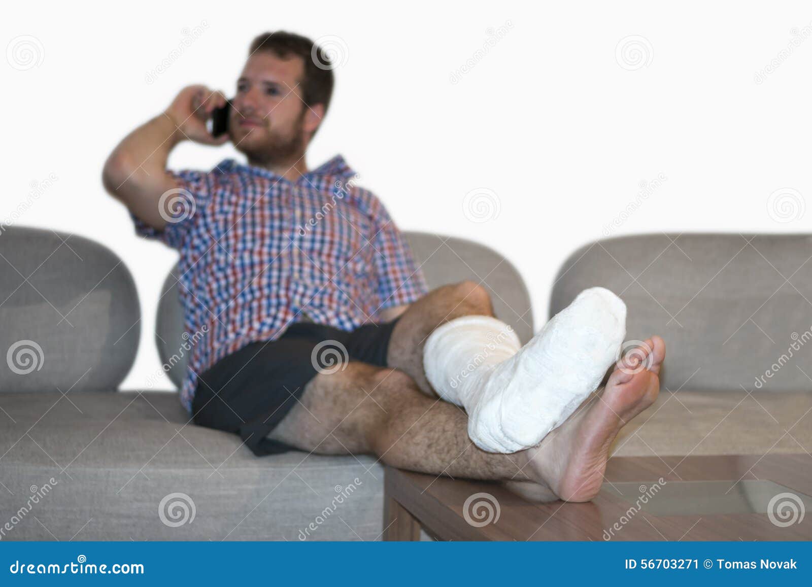 Man with Fractured Leg Sitting on Sofa Talking on Cellphone Stock Image ...