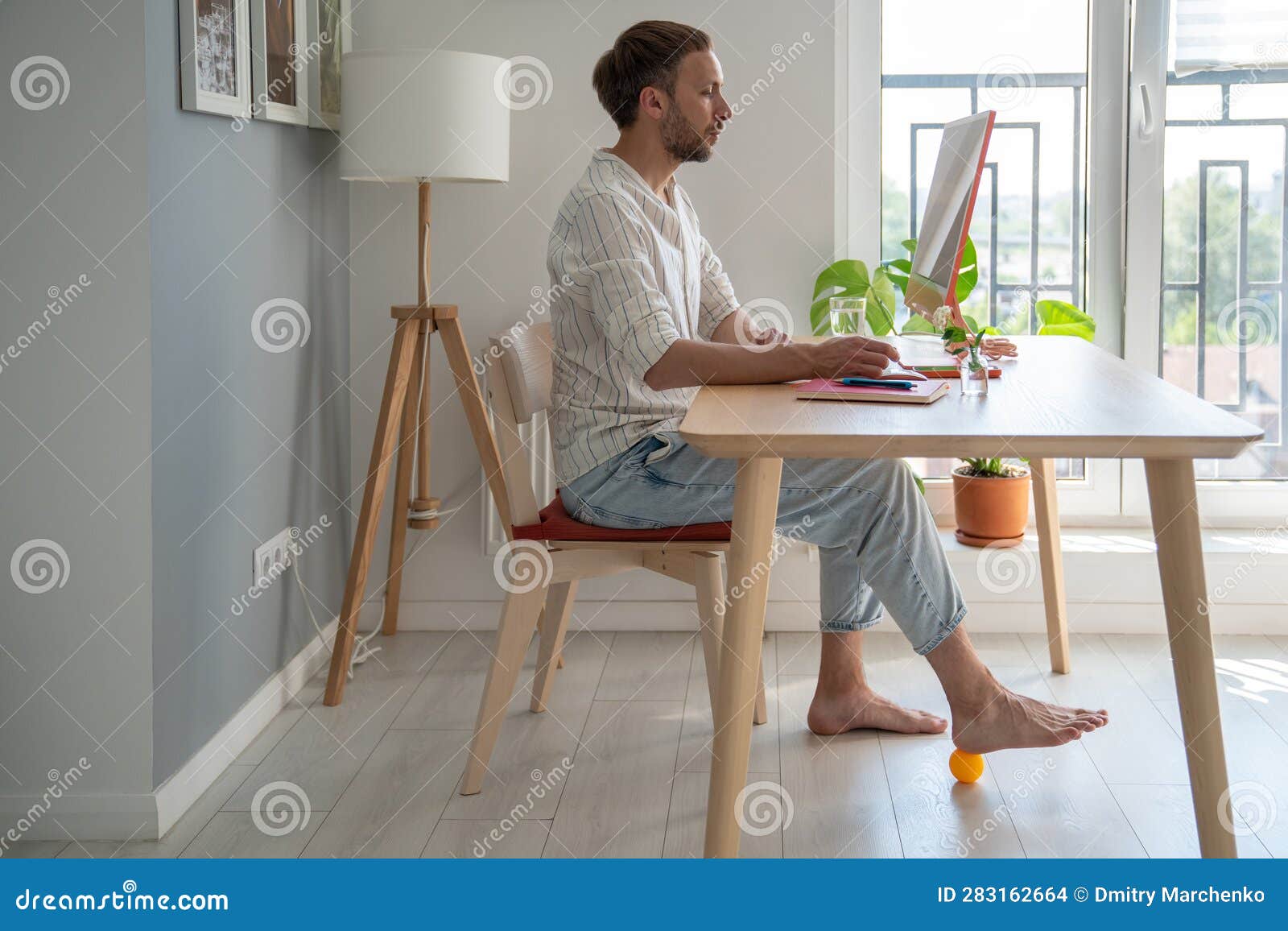 Man Freelancer Working on Computer at Home Doing Recovery Foot Exercise ...