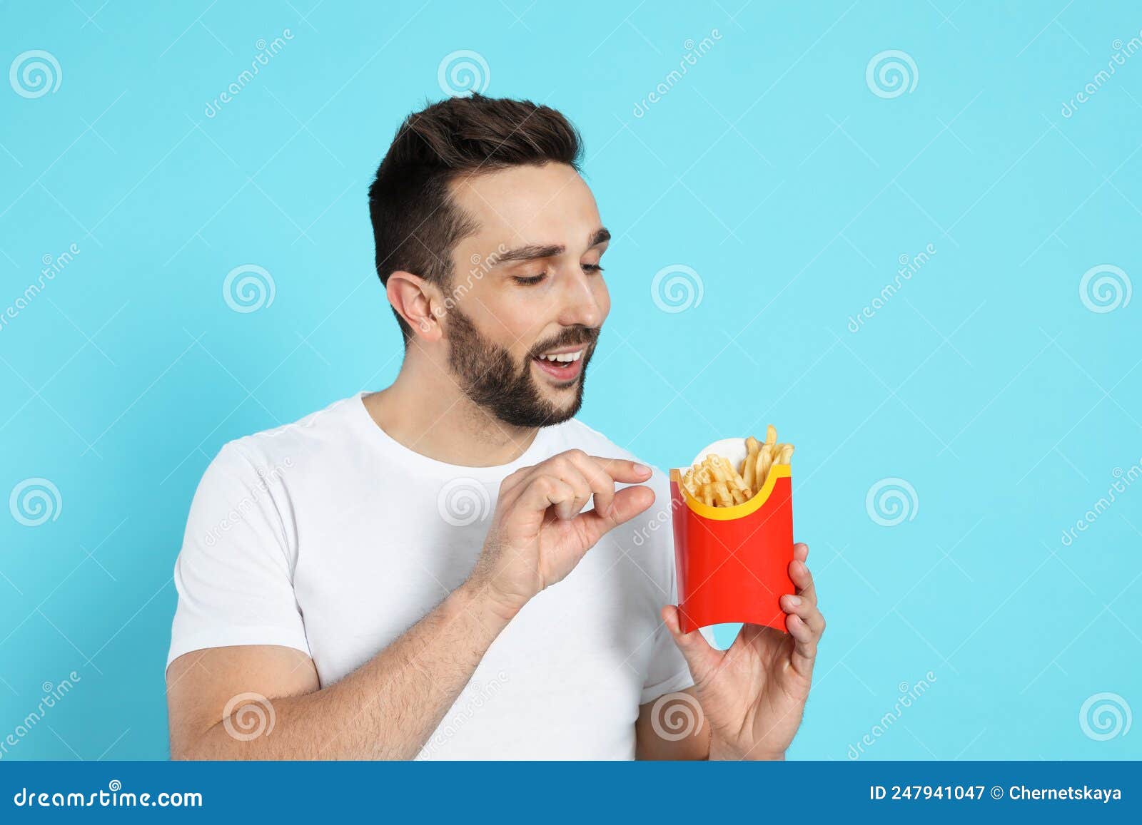 Man with French Fries on Light Blue Background Stock Image - Image of ...
