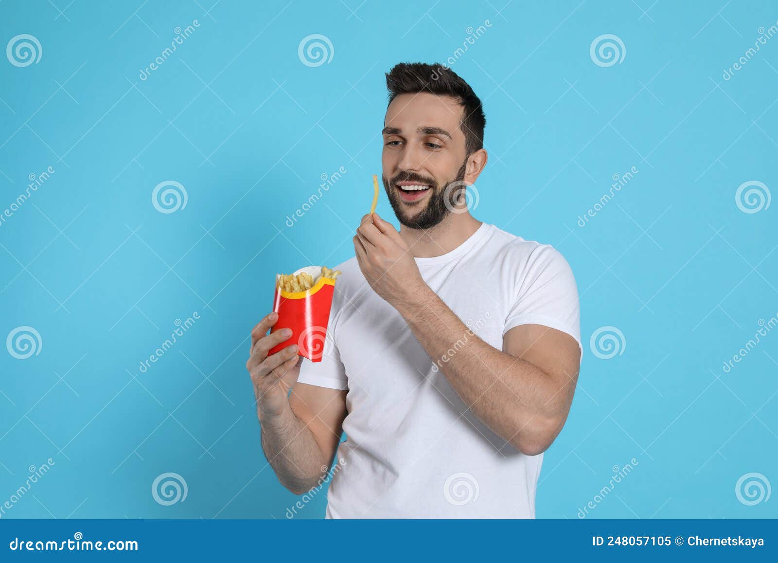 Man with French Fries on Light Blue Background, Space for Text Stock ...