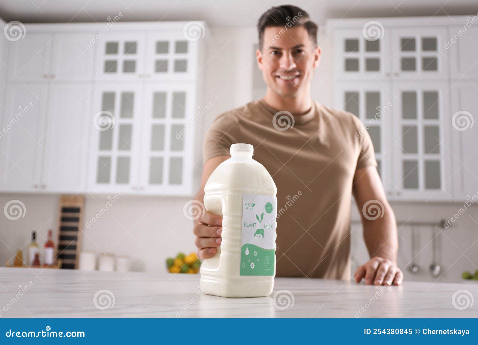 Man with Gallon Bottle of Vegan Milk at Marble Table in Kitchen Stock ...