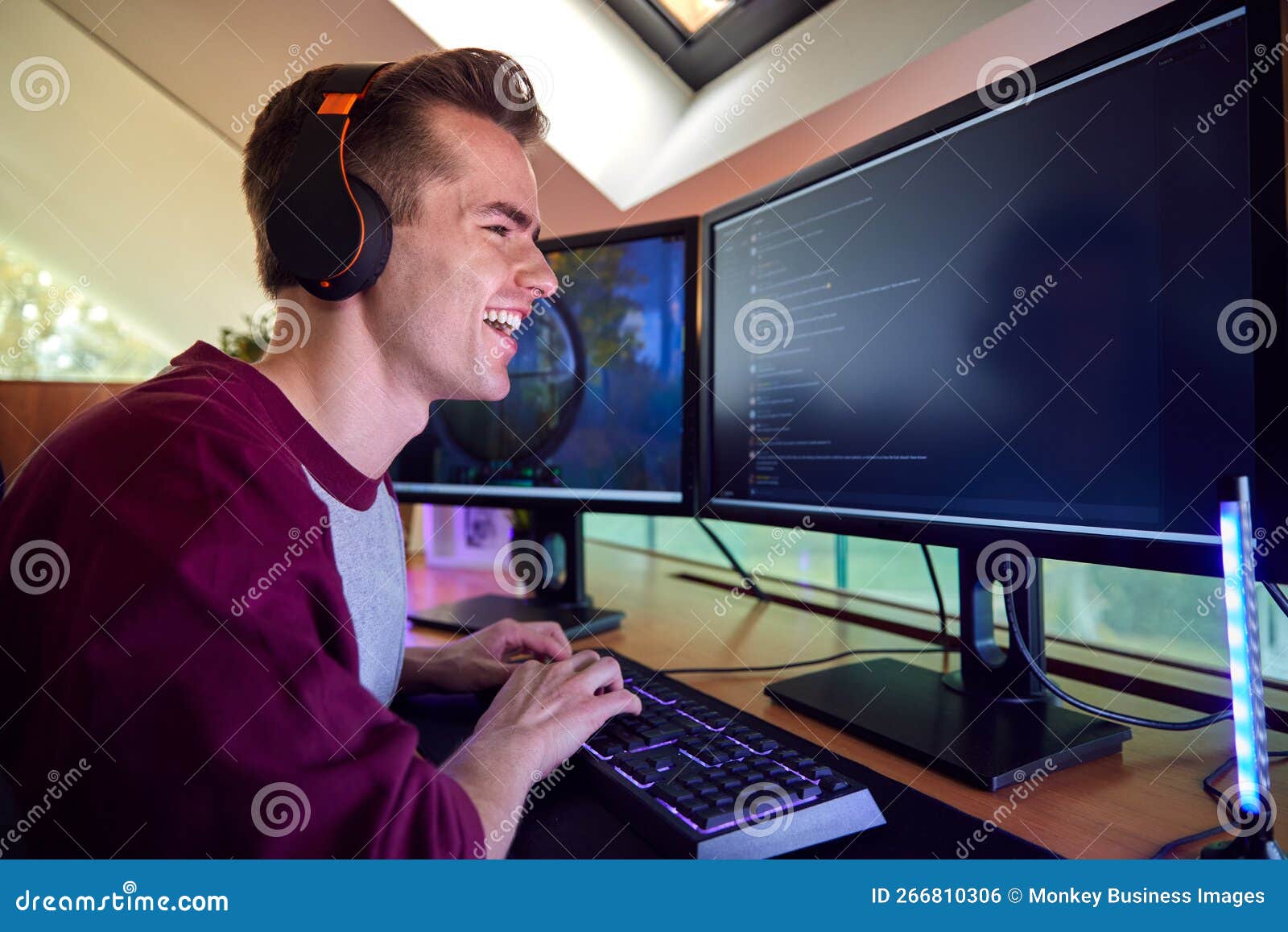 Man Gaming at Home Sitting at Desk with Multiple Monitors Stock Photo ...