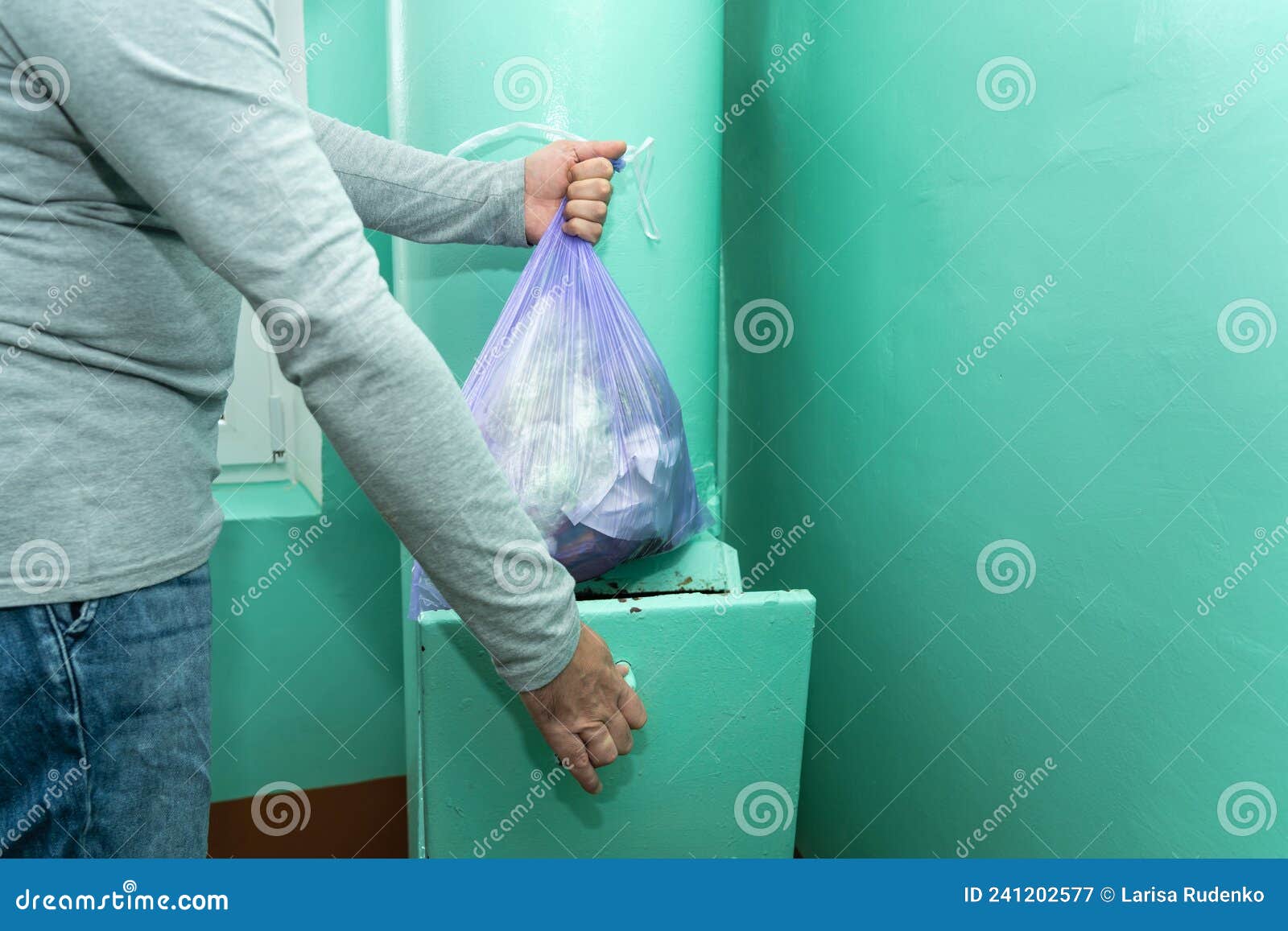 A Man with a Garbage Bag Opens the Hatch of the Garbage Chute and ...