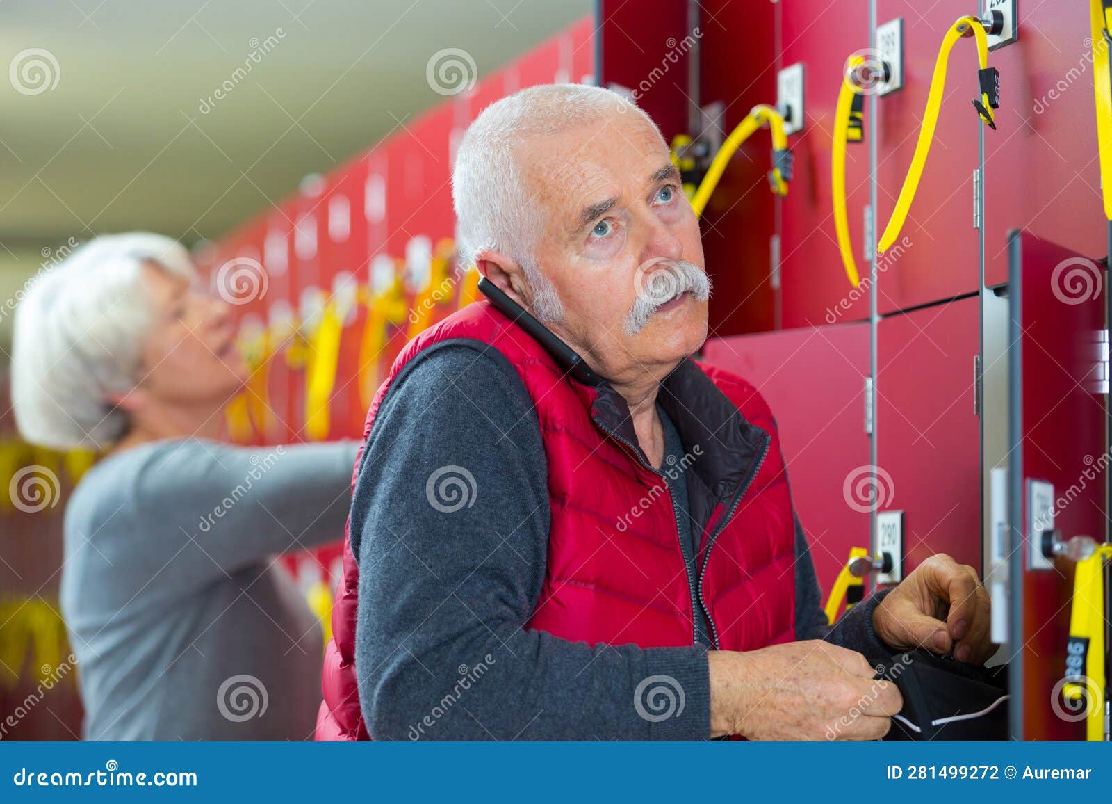 Man Getting Bag from Locker with Smartphone Balanced on Shoulder Stock ...