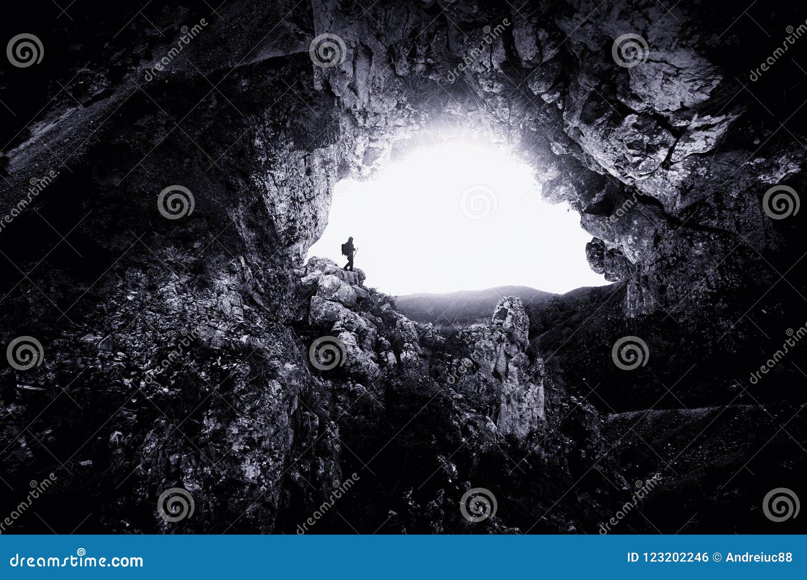 Man at Giant Cave Entrance with Steep Cliffs Stock Photo - Image of ...