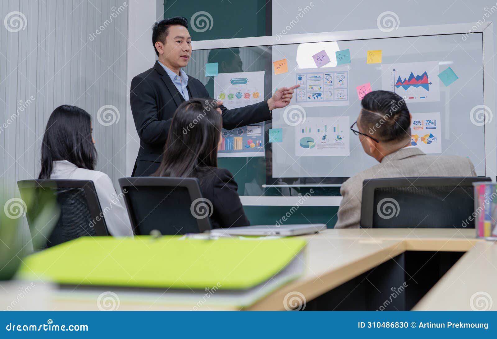 A Man is Giving a Presentation To Group of People in a Conference Room ...