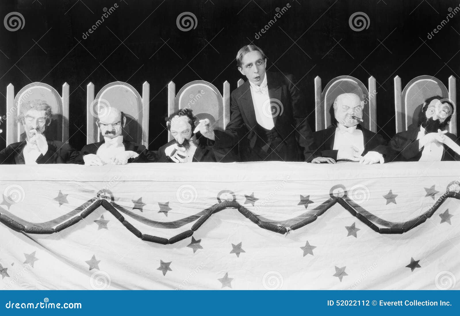 Man Giving a Speech with Five Character Puppets Sitting at the Table ...