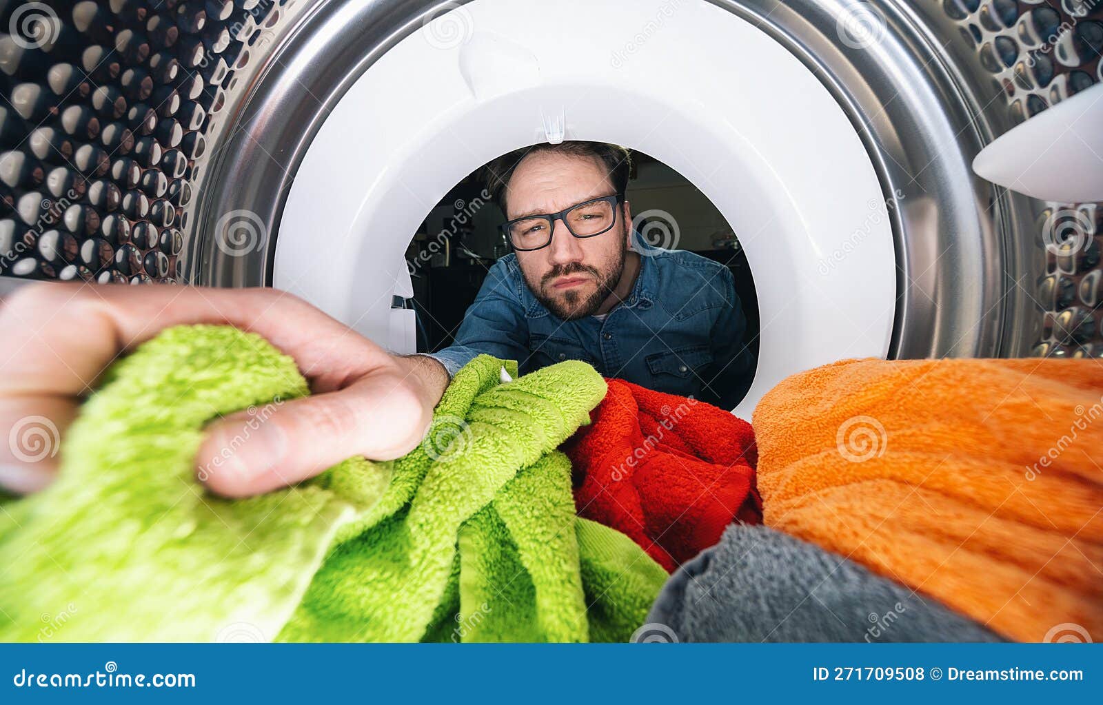 Man with Glasses Reaching Inside a Washing Machine or Dryer Doing ...