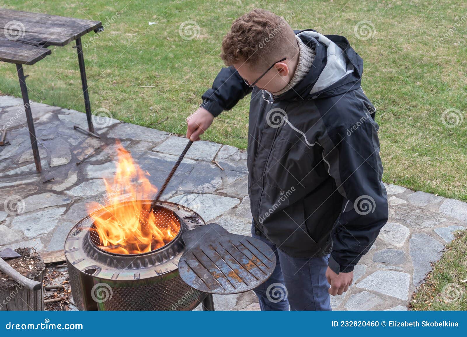 A Man with Glasses Watches the Fire Stock Photo - Image of spring, rest ...