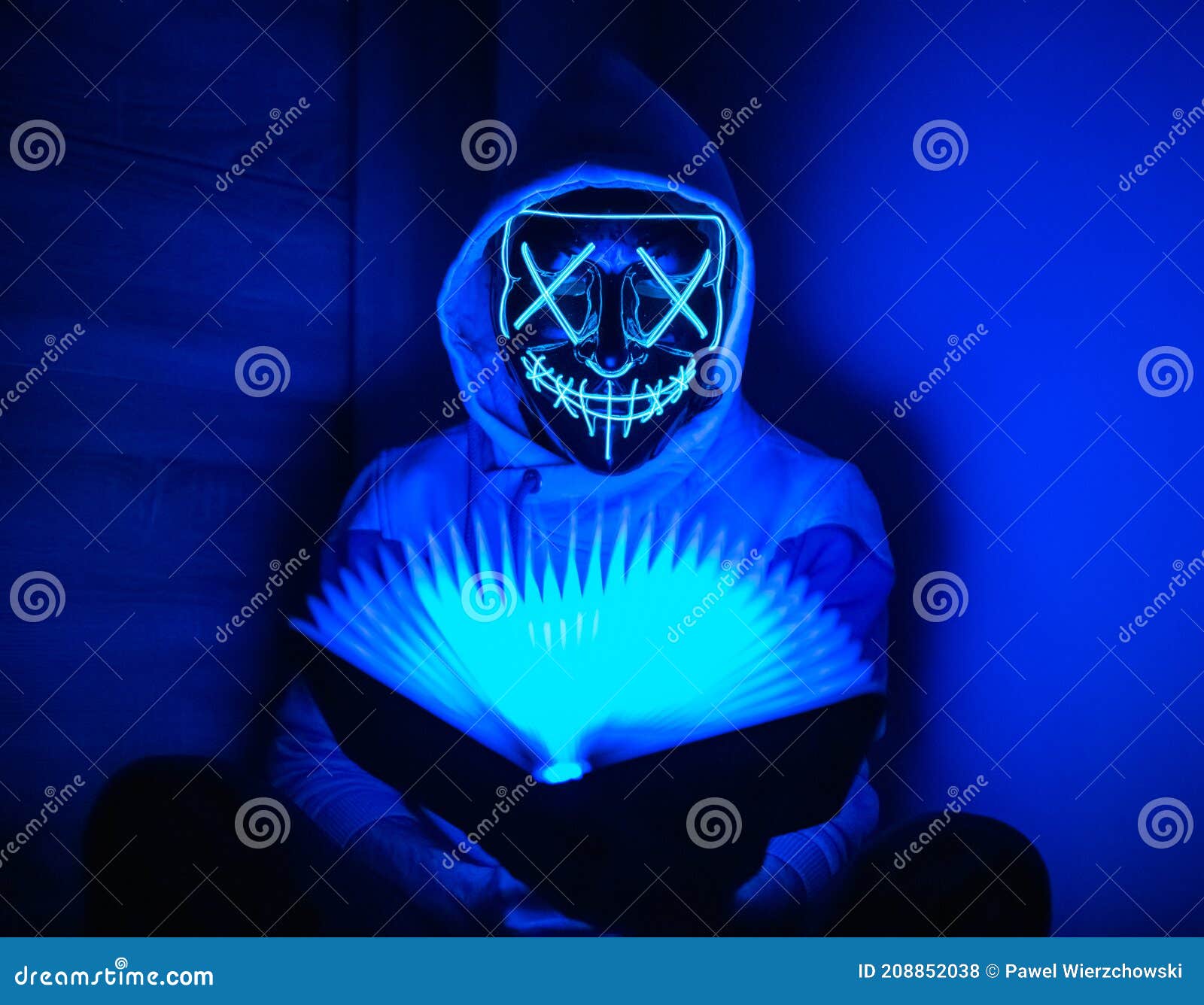 Man in Glowing Mask Sitting in the Corner with Book-shaped Lamp Stock ...