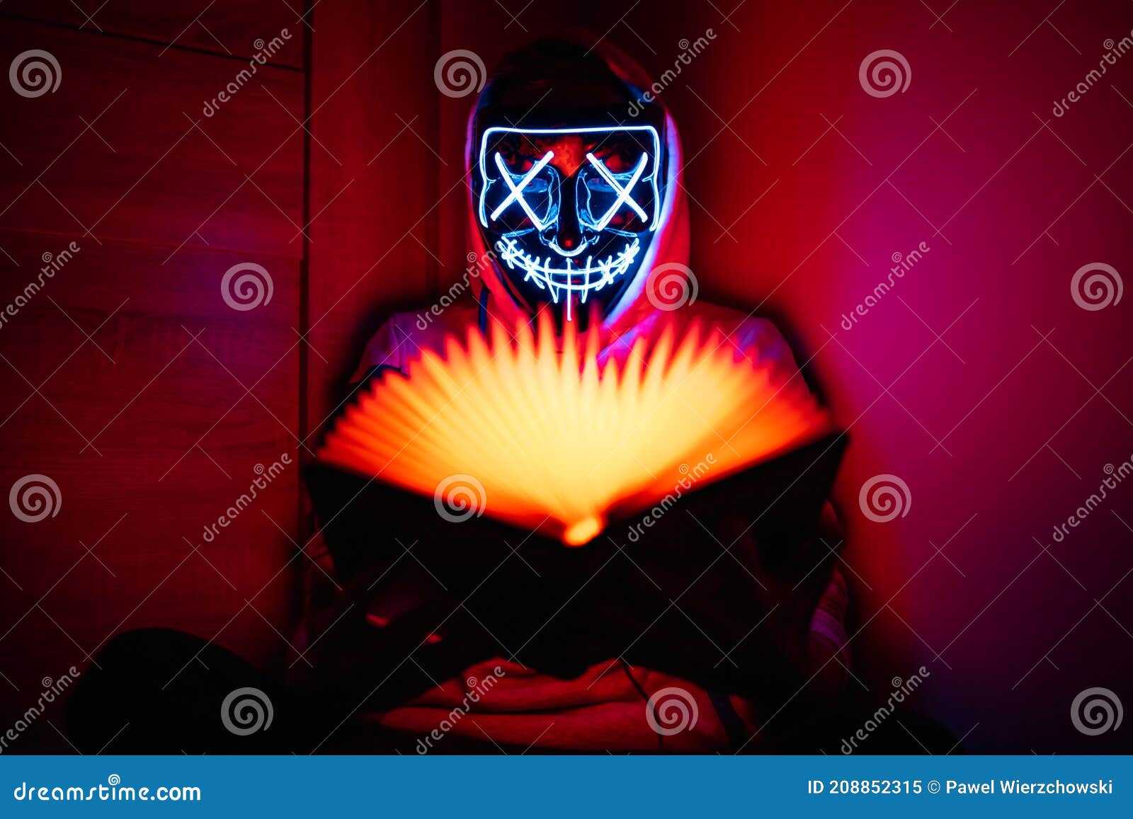 Man in Glowing Mask Sitting in the Corner with Book-shaped Lamp Stock ...