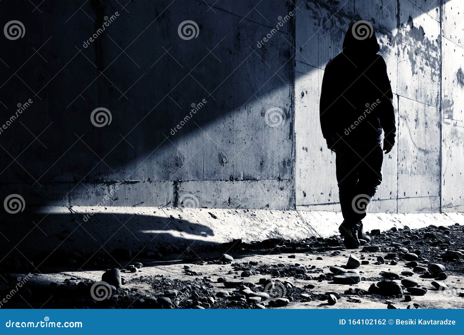 A Man Going Out of an Abandoned Tunnel Leaving a Strong Shadow Behind ...
