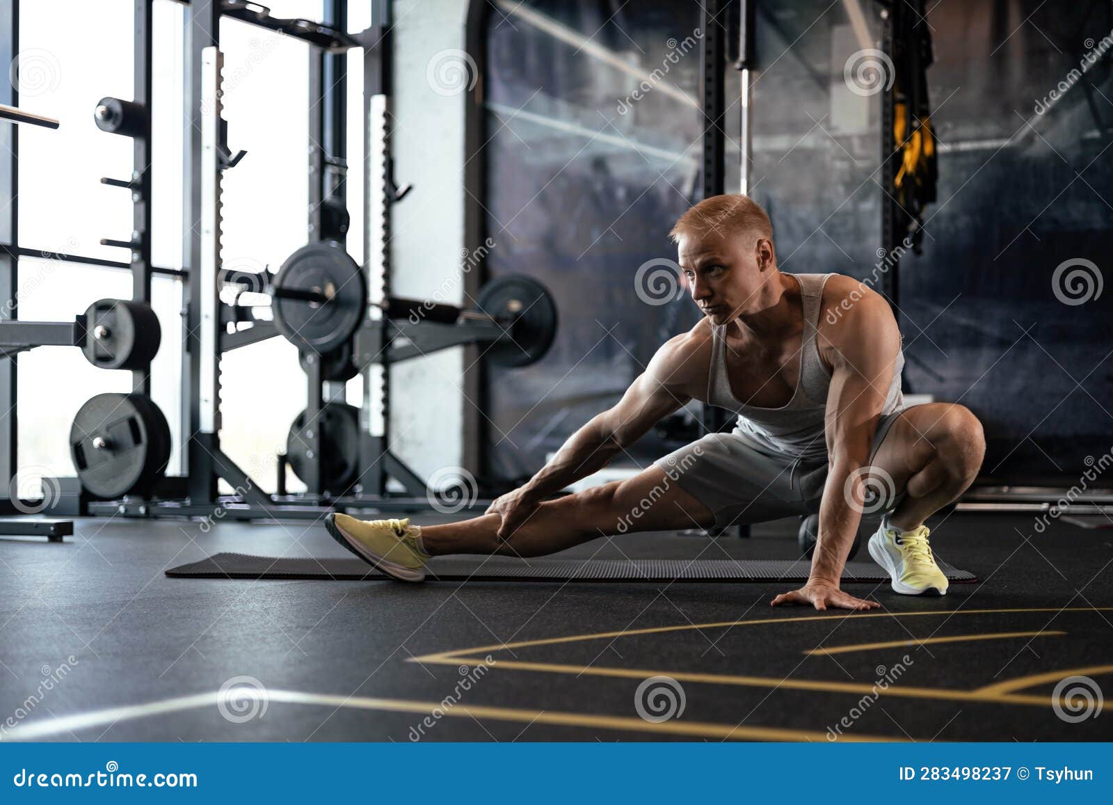 Man at the Gym Doing Stretching Exercises on the Floor. Stock Image ...