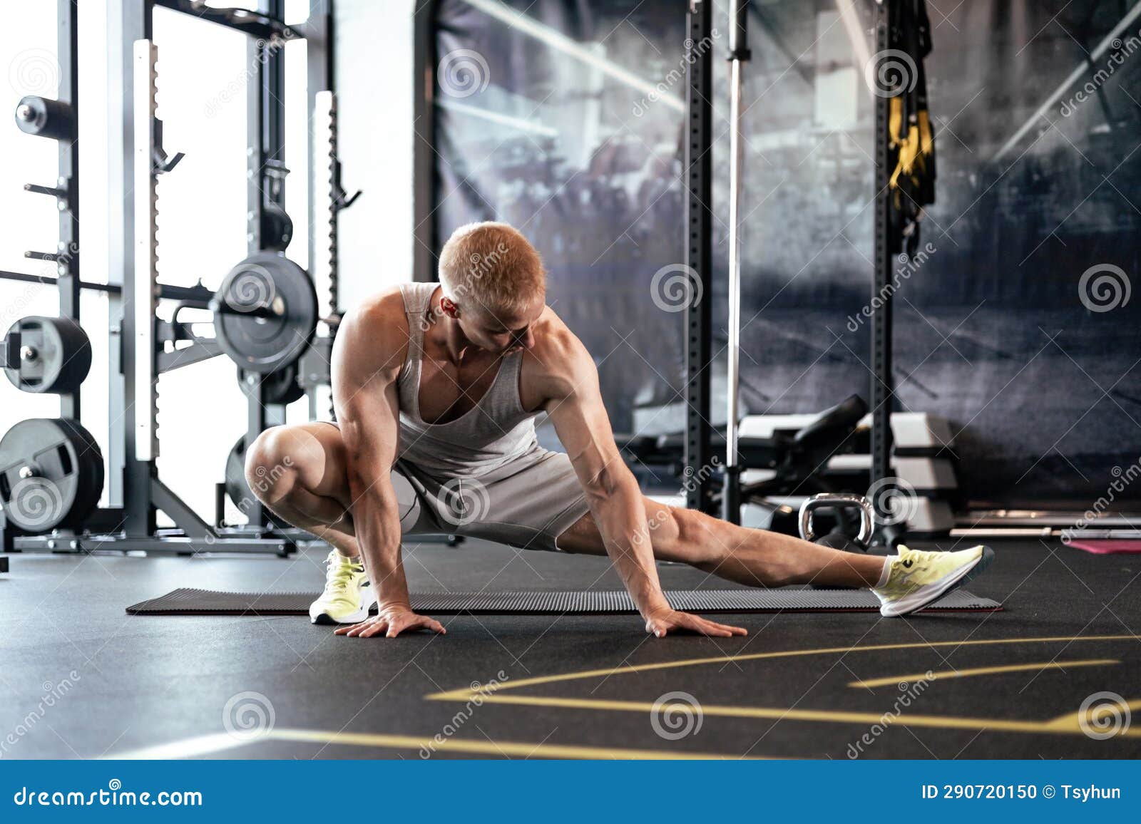 Man at the Gym Doing Stretching Exercises on the Floor. Stock Photo ...