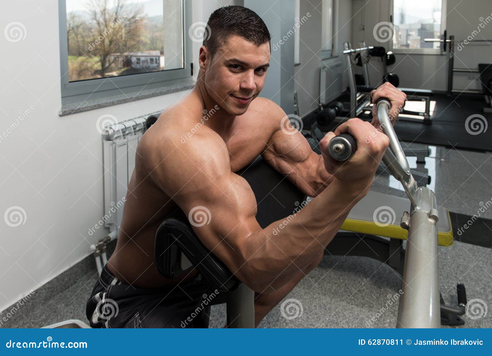 Man in the Gym Exercising Biceps on Machine Stock Image - Image of ...