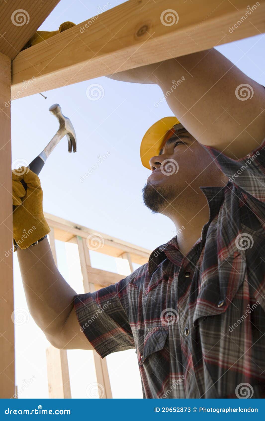 Man Hammering Nail at Site stock image. Image of latin - 29652873