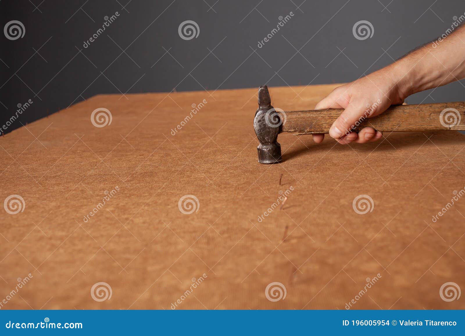 A Man Hammers Nails into a Cupboard. the Back Wall of the Cupboard is ...
