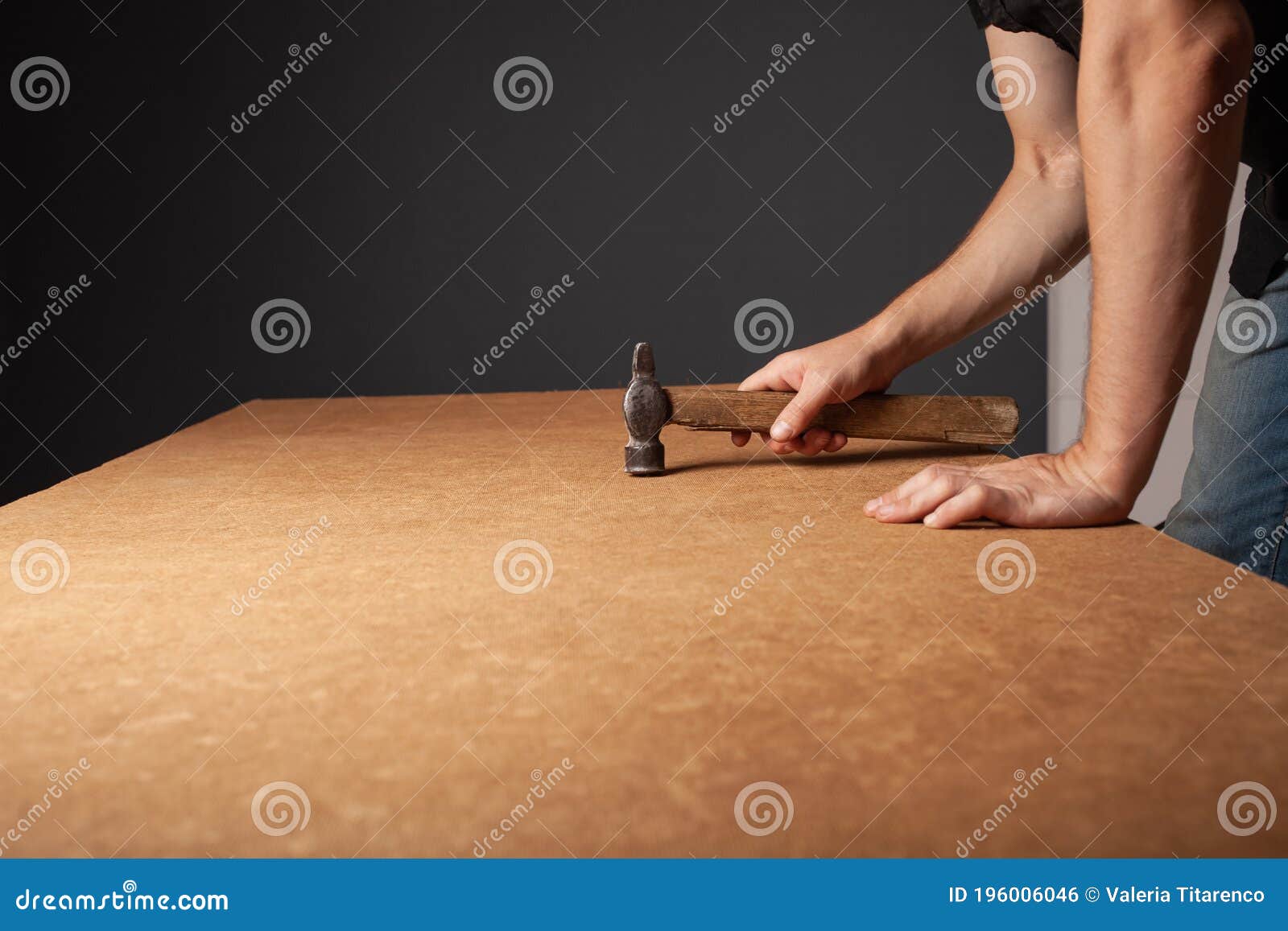 A Man Hammers Nails Into A Cupboard. The Back Wall Of The Cupboard Is ...