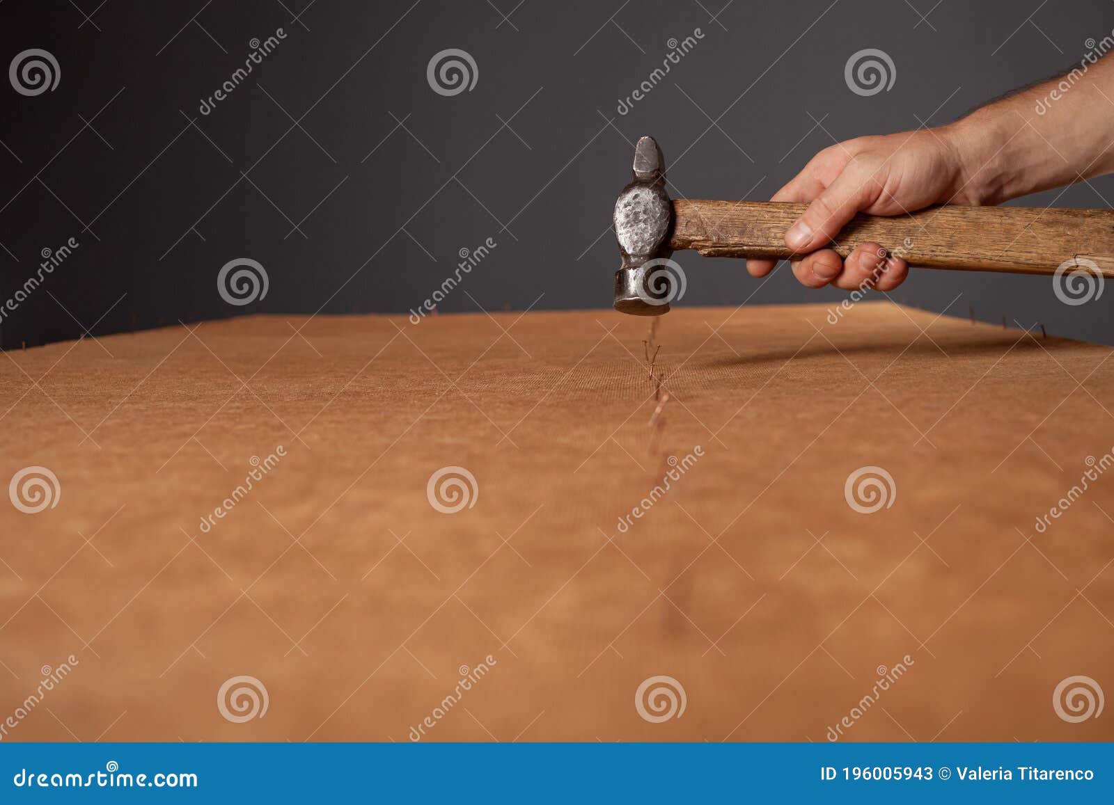 A Man Hammers Nails into a Cupboard. the Back Wall of the Cupboard is ...