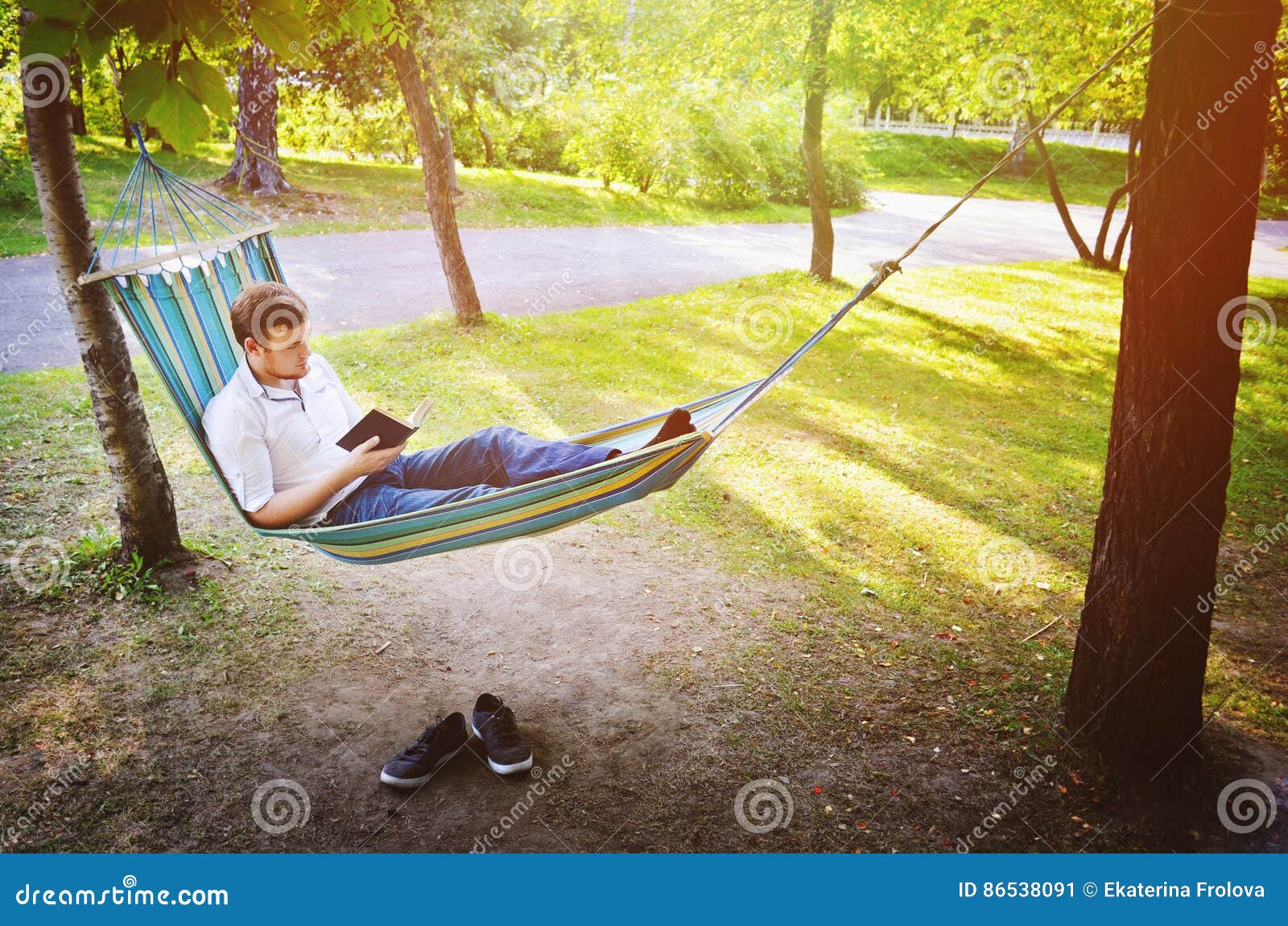 A Man in Hammock Reads a Book Stock Image - Image of comfort, bright ...