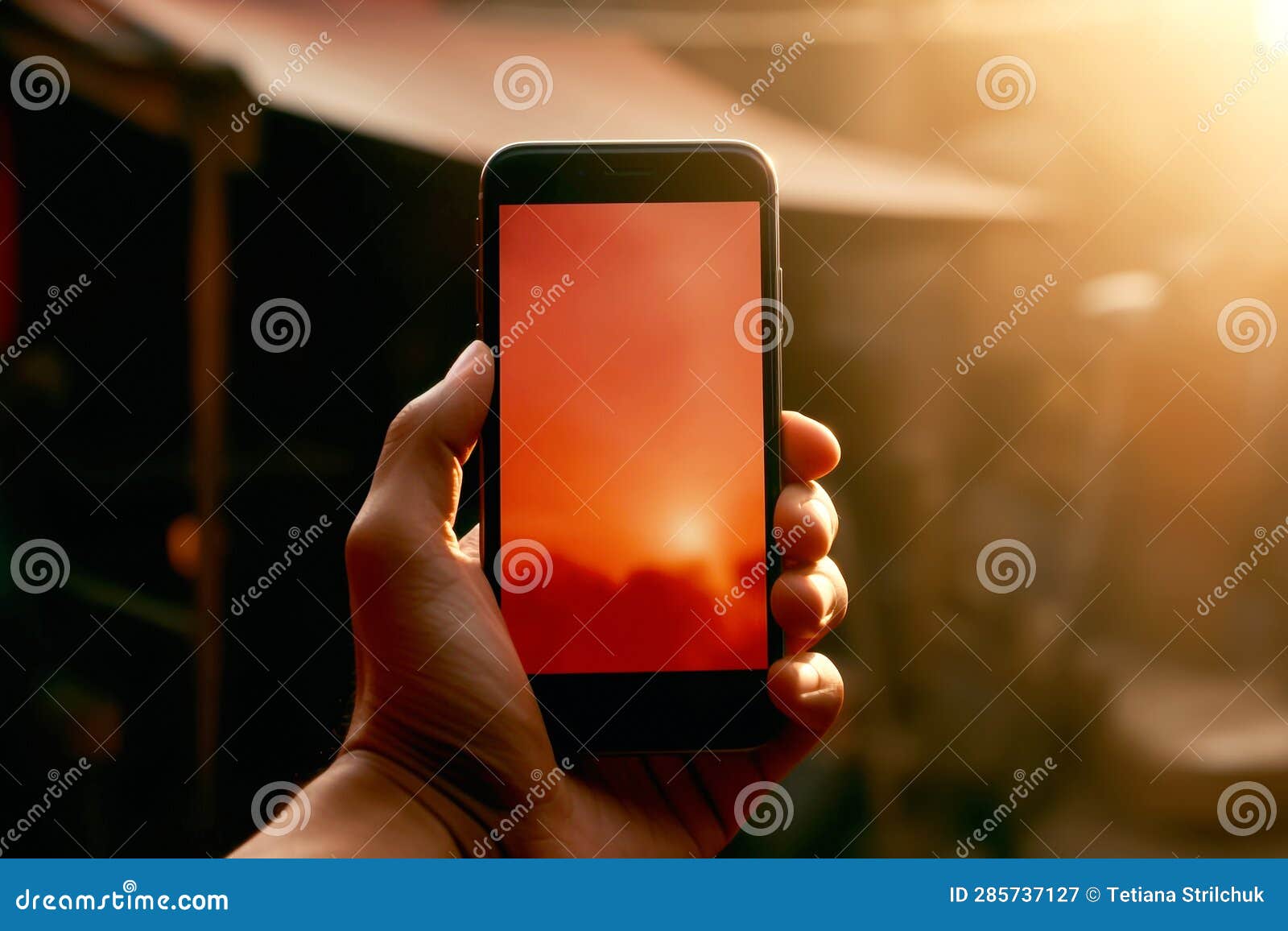 Man Hand Holding Black Smartphone with Orange Screen on Sunset ...