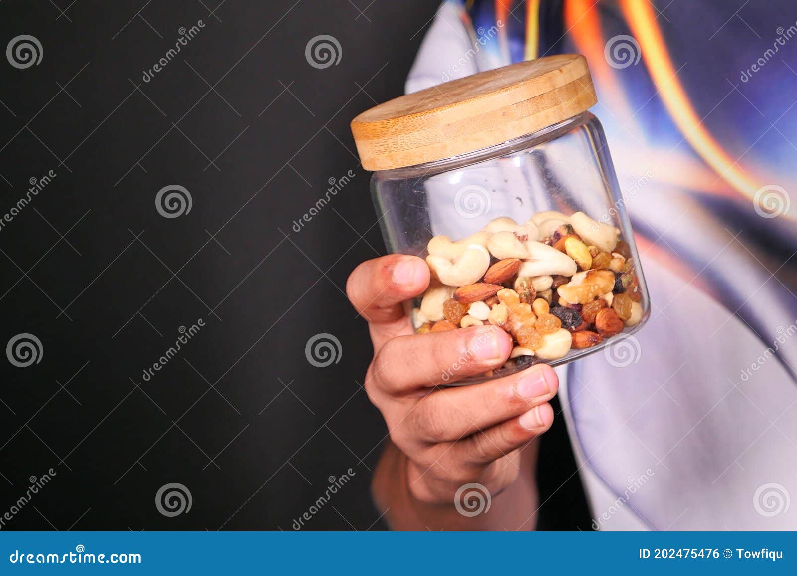 Man Hand Holding a Jar of Mixed Nut Isolated on Black Stock Photo ...