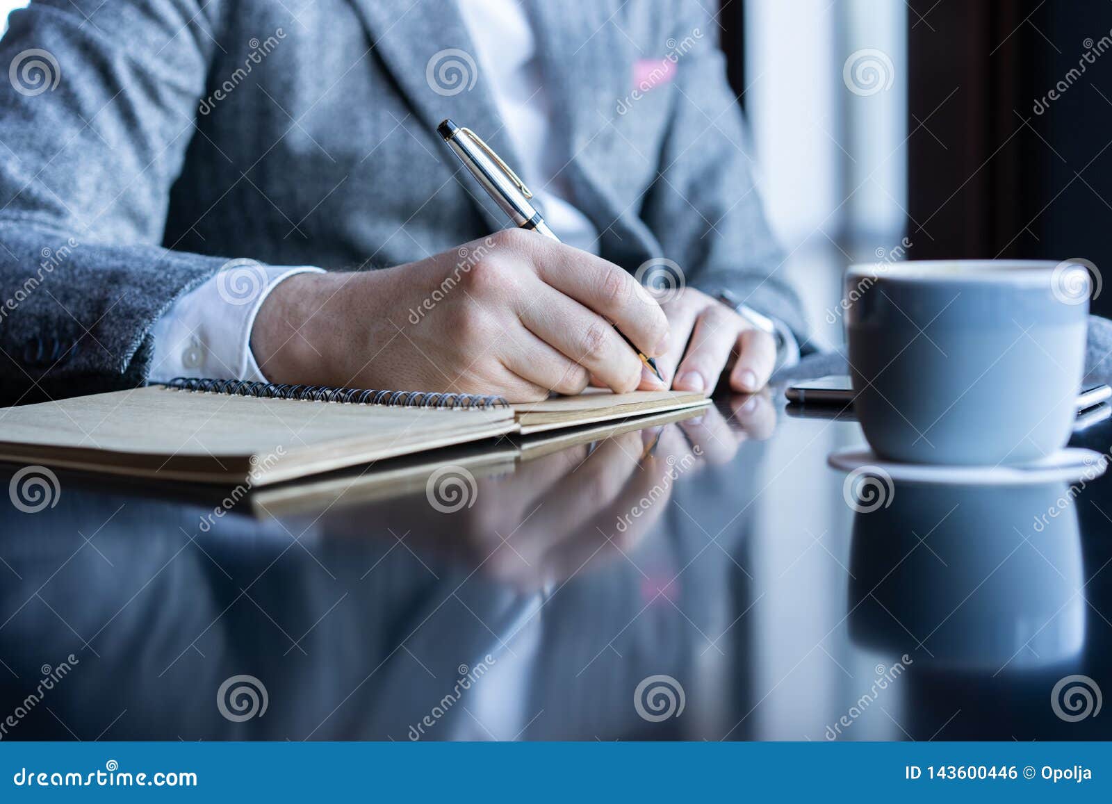 Man Hand with Pen Writing on Notebook on Table. Man Working at Coffee ...