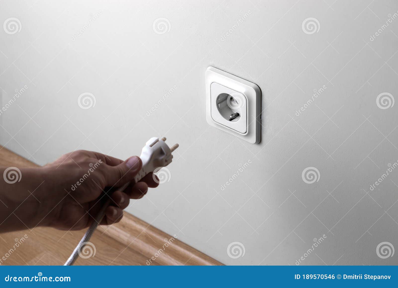 Man Hand Plugging Electric Plug a in a Socket on the Wall Stock Photo ...