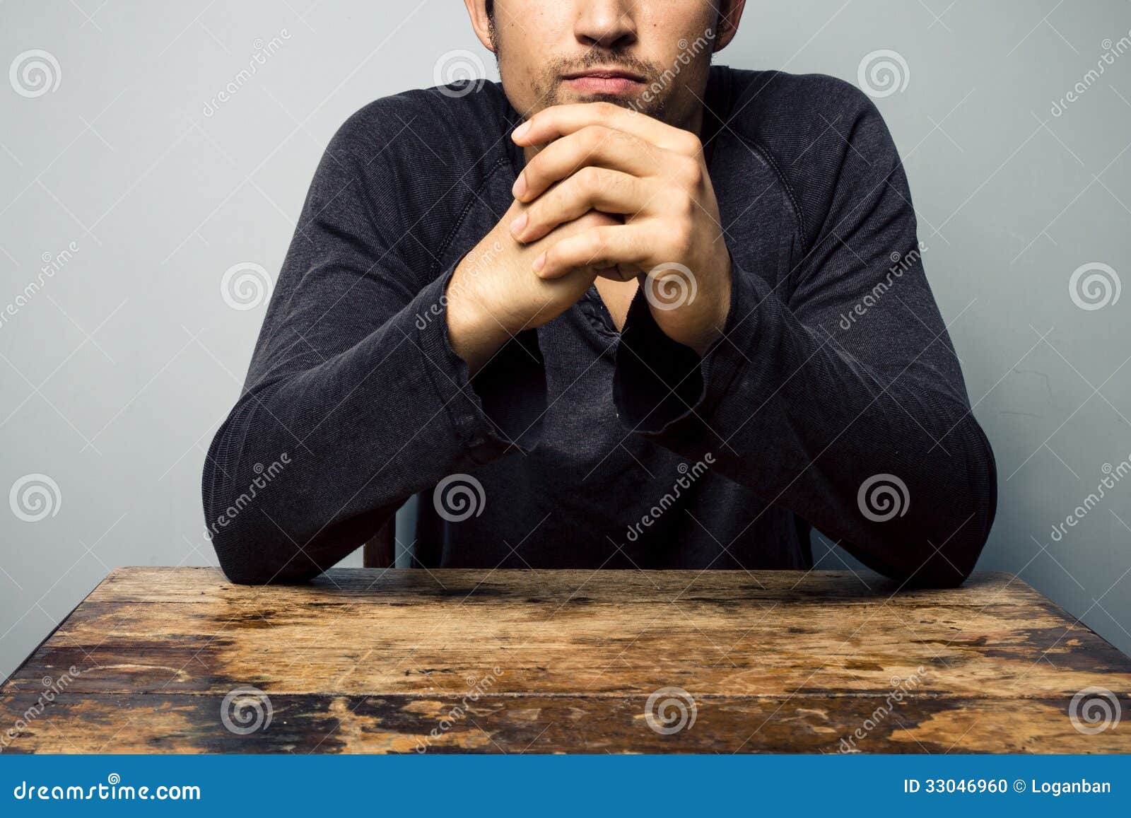 Man with Hands Clasped Sitting at Desk Stock Photo - Image of wood ...