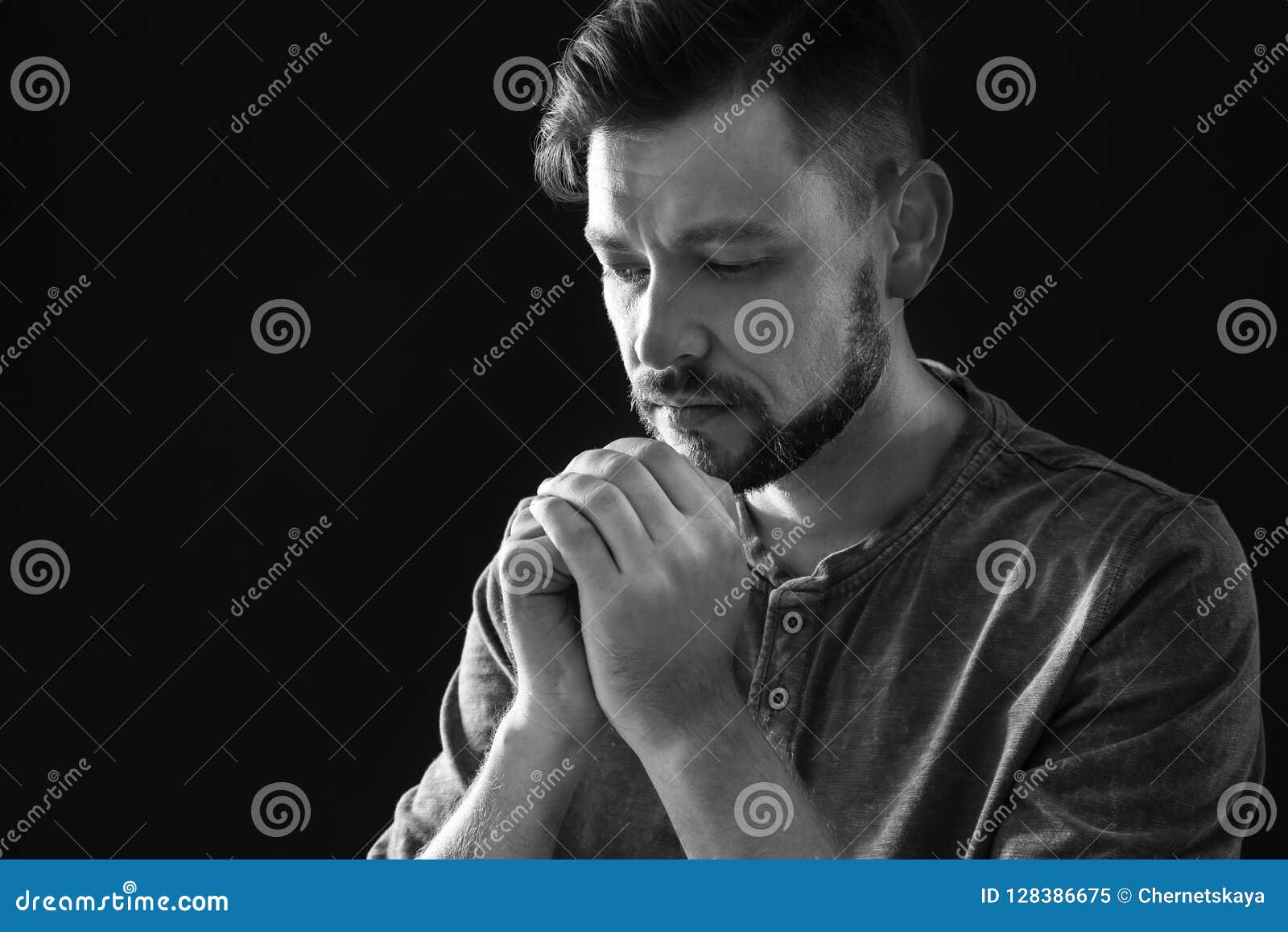 Man With Hands Clasped Together For Prayer On Dark Background Black