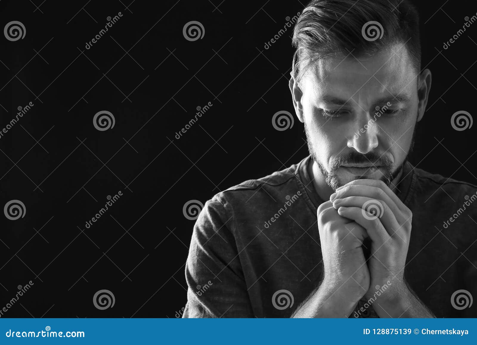 Man With Hands Clasped Together For Prayer On Dark Background Black