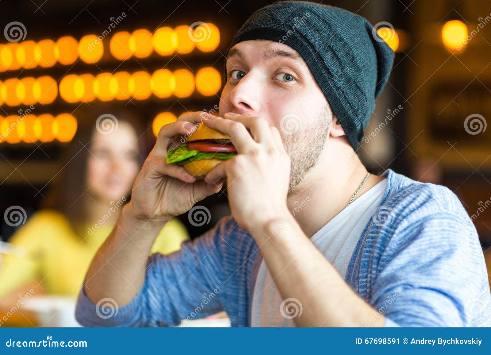 Man in Hands Holds a Burger. Man Eating a Burger at the Cafe Stock ...