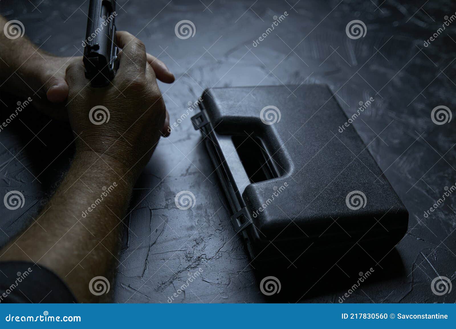 Man Hands with Weapon and Suitcase from Under Pistol on Concrete Table ...