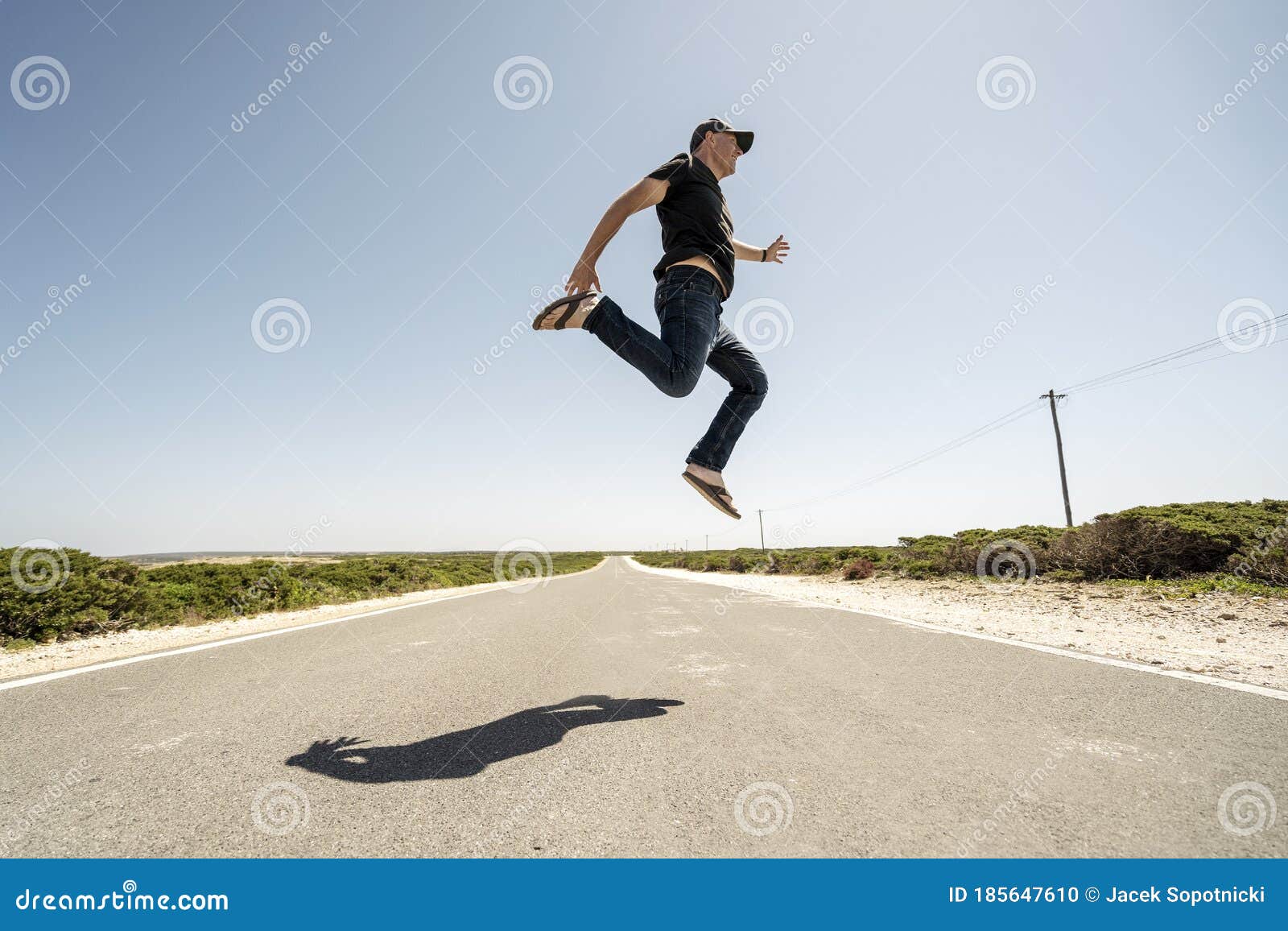Man Happily Jumping High Above the Road Stock Photo - Image of ...