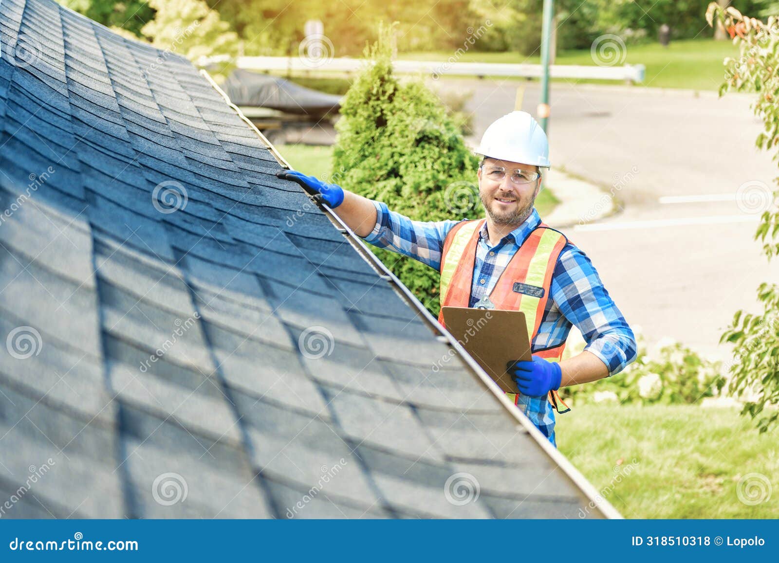 Man with Hard Hat Standing on Steps Inspecting House Roof Stock Photo ...