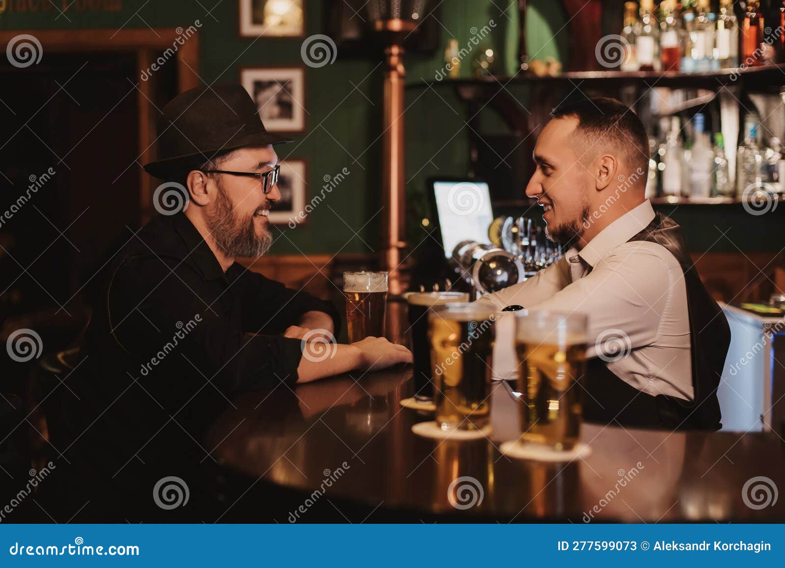 Man Has Fun Chatting with a Bartender at Bar Counter with a Glass of ...