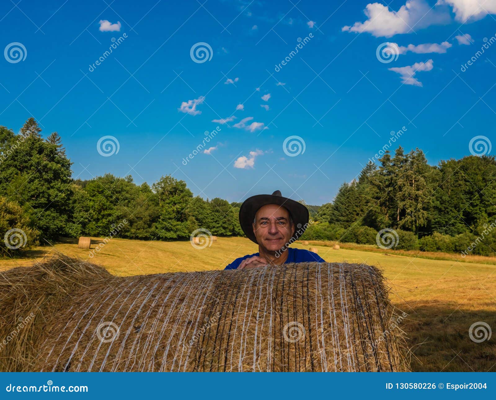 Man in a Hat Behind a Haystack in the Field.. Stock Photo - Image of ...