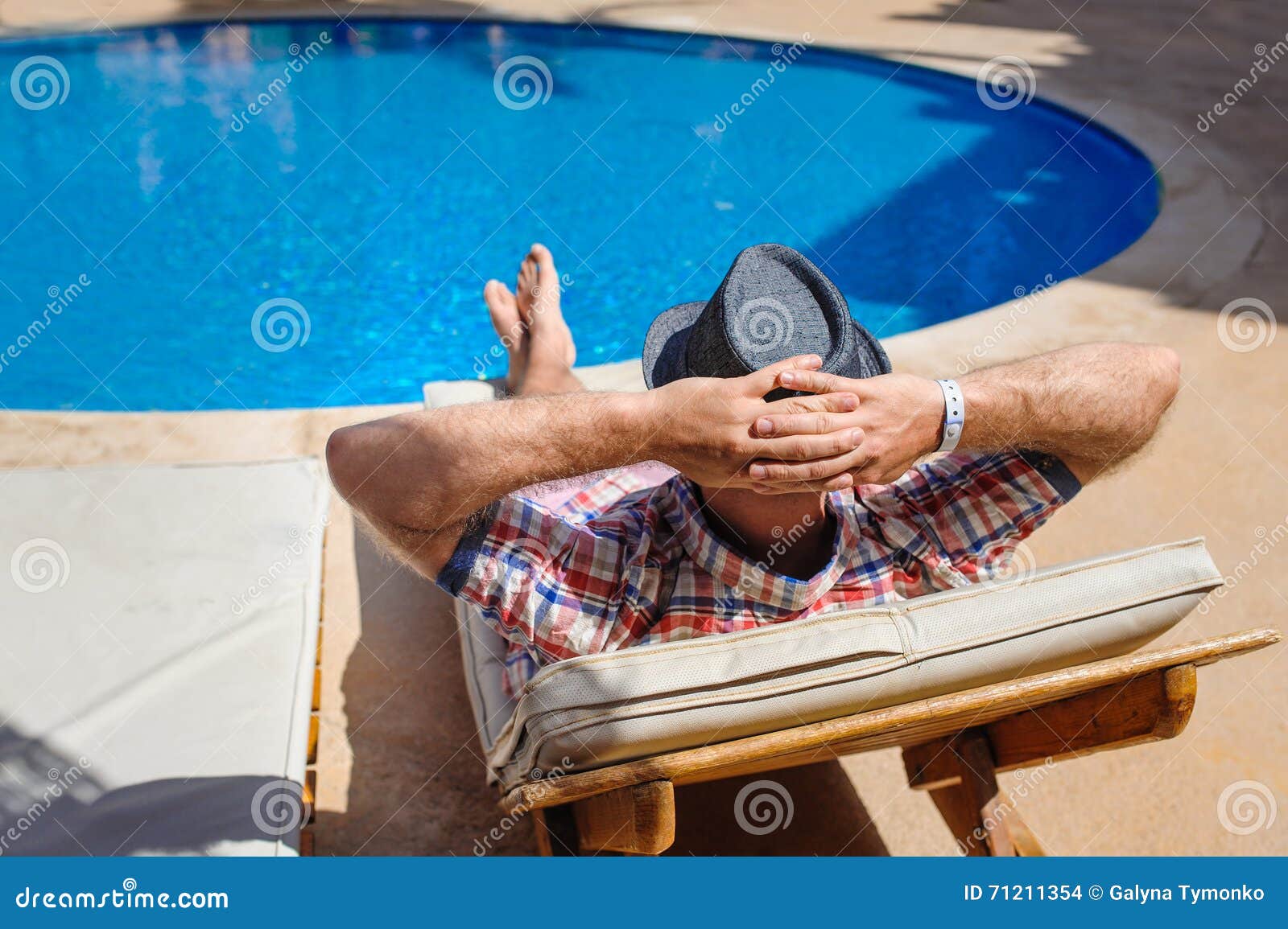 Man in Hat Sunbathing on a Sun Lounger by the Pool Stock Photo - Image ...