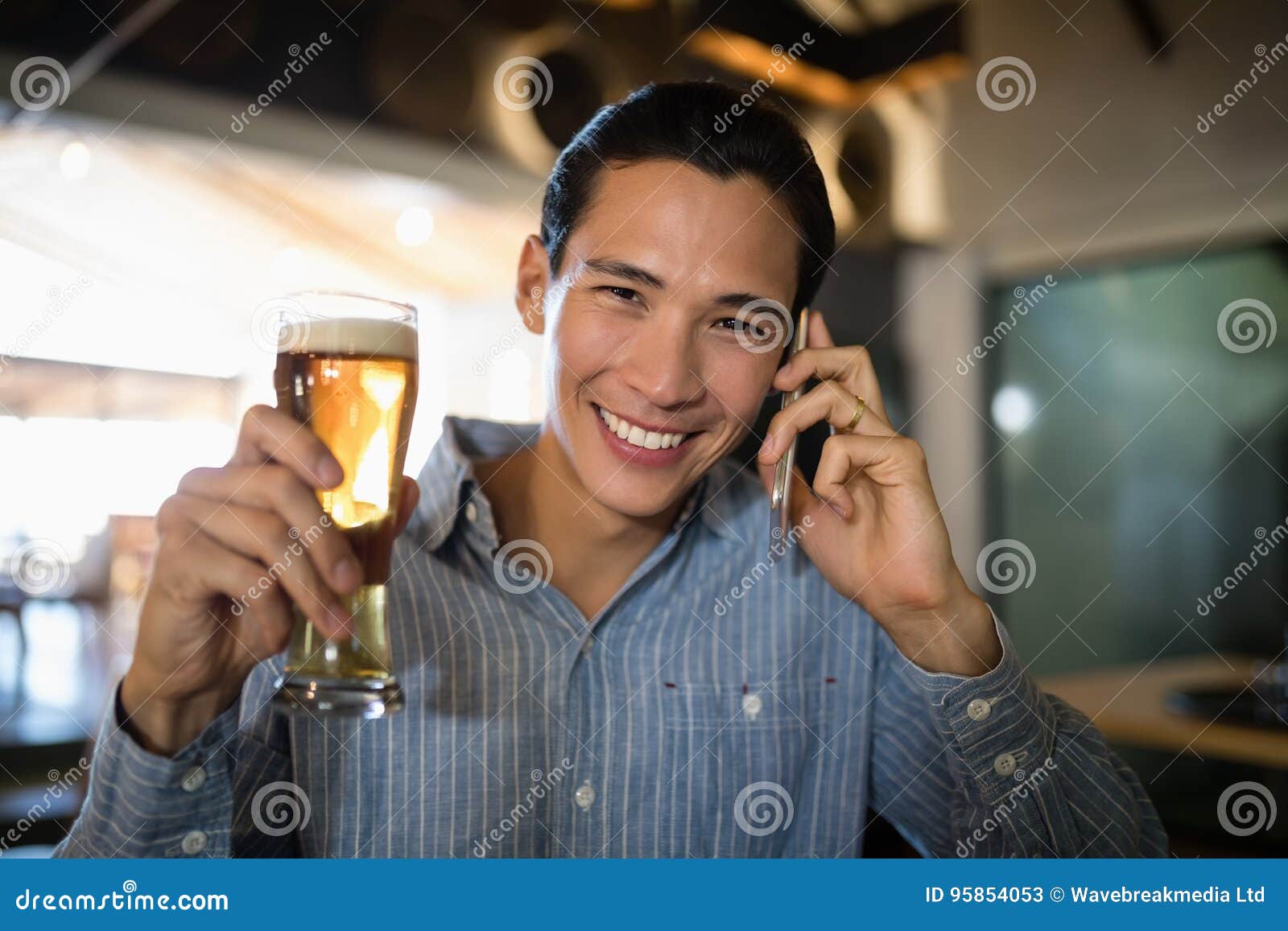 Man Having Beer while Talking on Mobile Phone Stock Image - Image of ...
