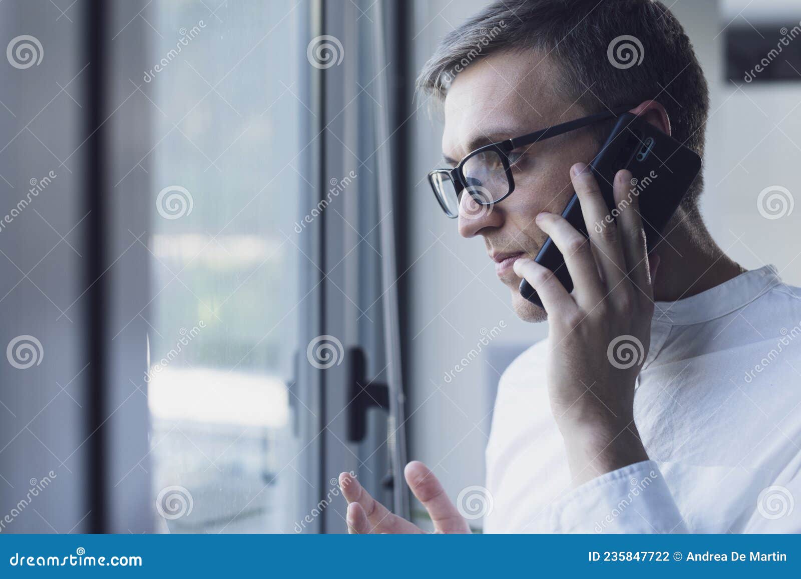 Man Having a Phone Call Next To a Window Stock Photo - Image of call ...